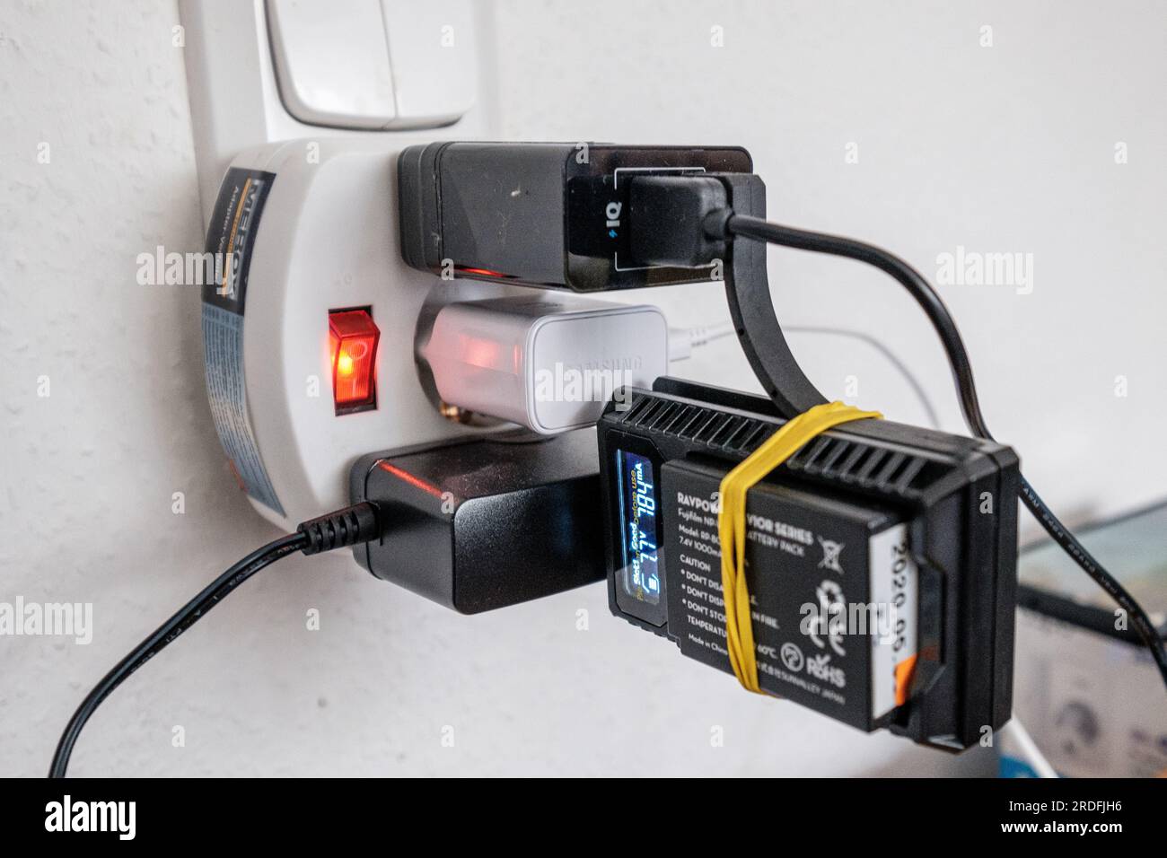 Over crowded wall socket Stock Photo - Alamy