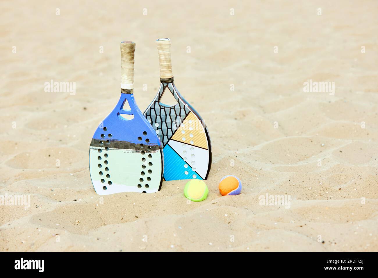 Paddle tennis racket and balls lying on sand. Summer type of game, warm ...