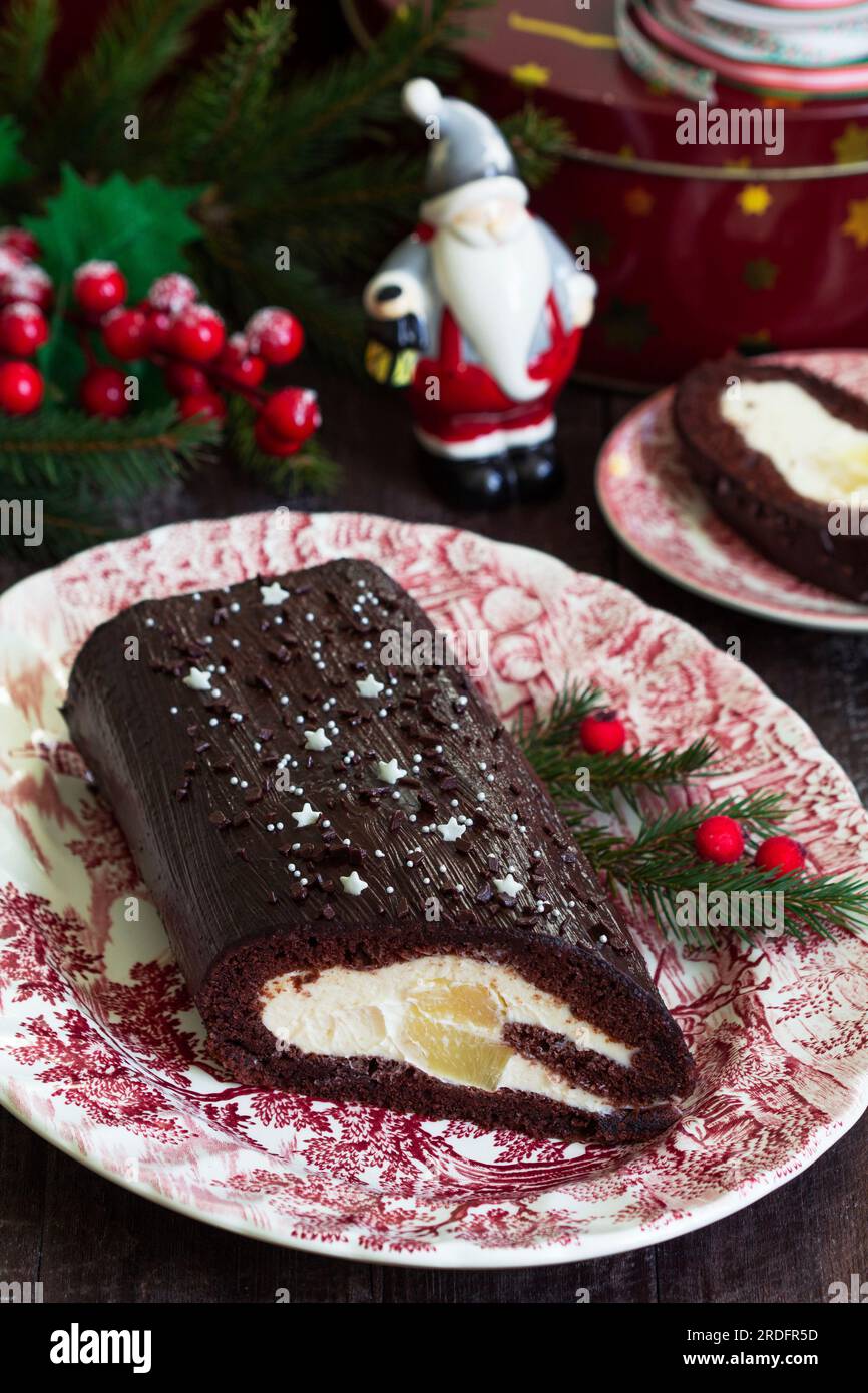 Chocolate roll stuffed with butter cream and pineapple on a Christmas ...