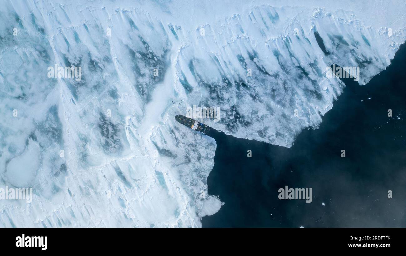 A look from above on a cruise ship making a path inside a huge ice rig ...