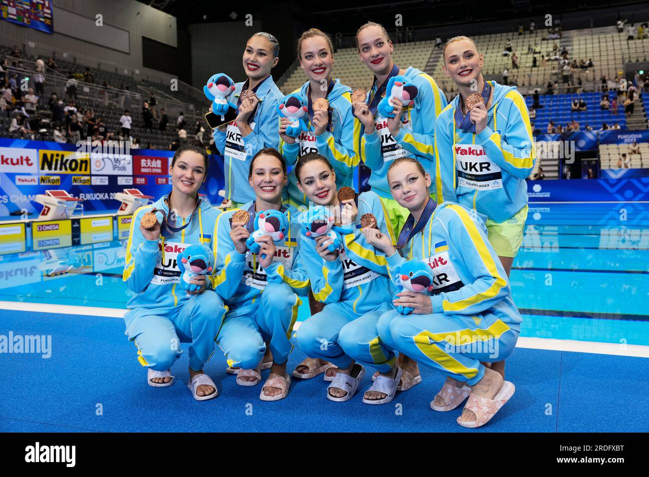 Ukraine team members holding bronze medals pose for a photo as they ...