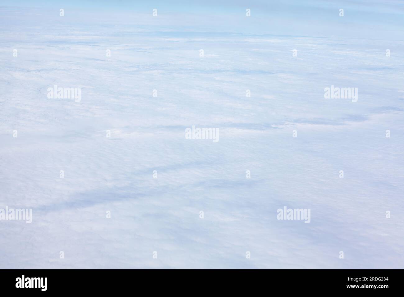 Snowy clouds in the sky as seen through window of an aircraft . Winter ...