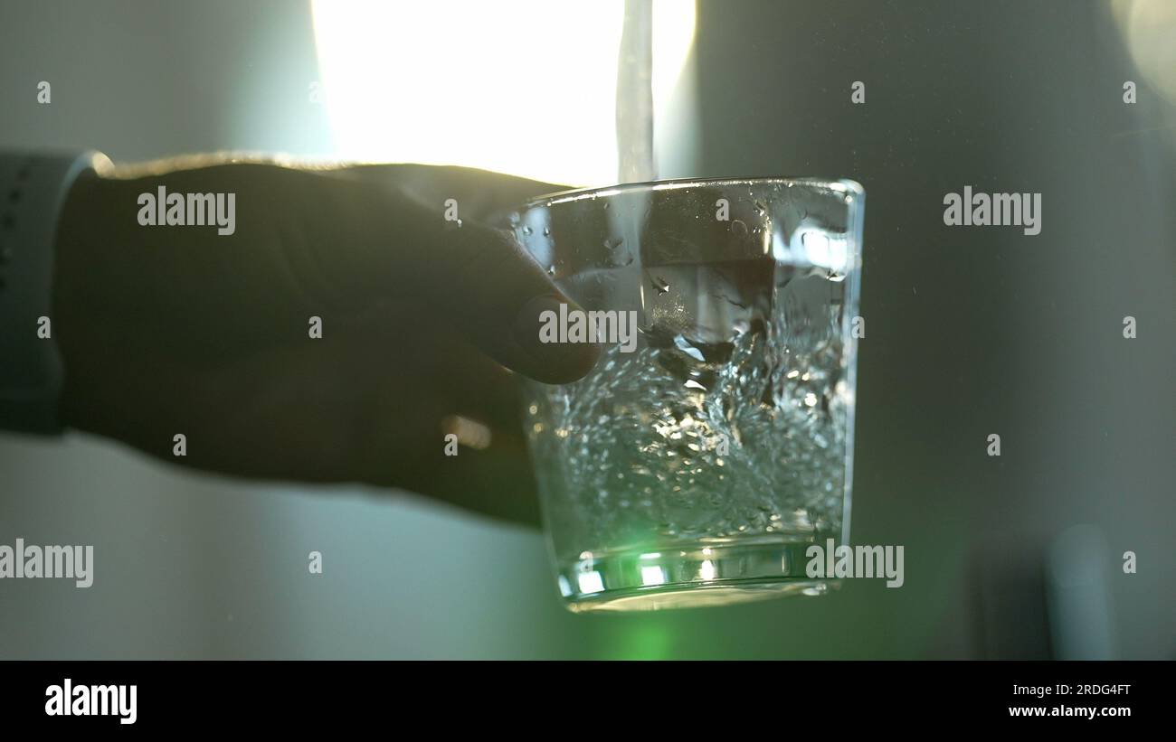 Hand holding glass filling water in slow motion fresh water tap from ...