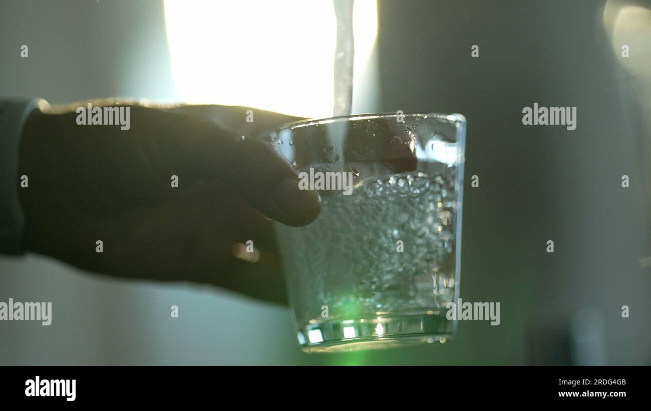 Hand holding glass filling water in slow motion fresh water tap from ...