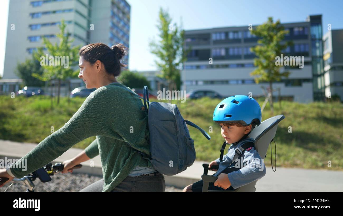Kid in bicycle back seat riding with mom Stock Photo - Alamy