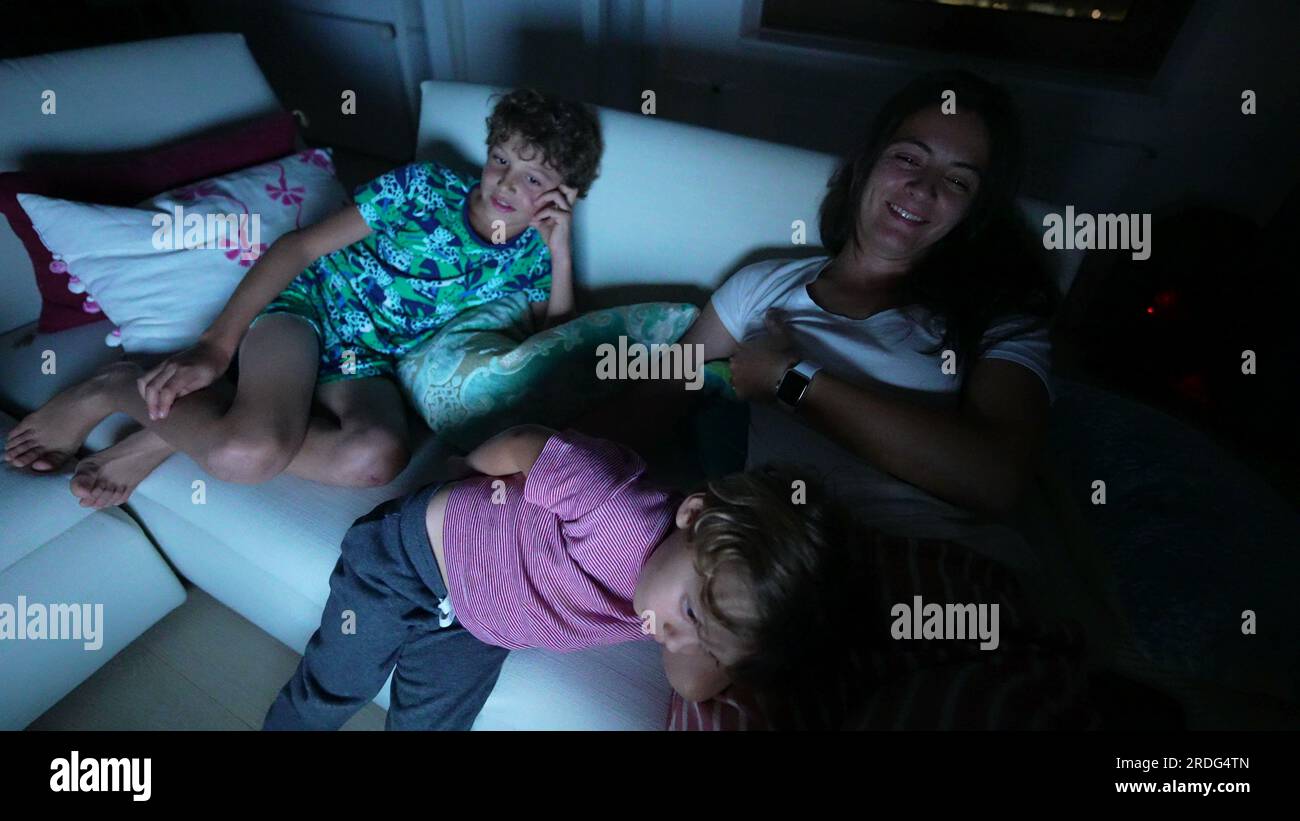 Kids sitting at couch at night watching movie Stock Photo - Alamy
