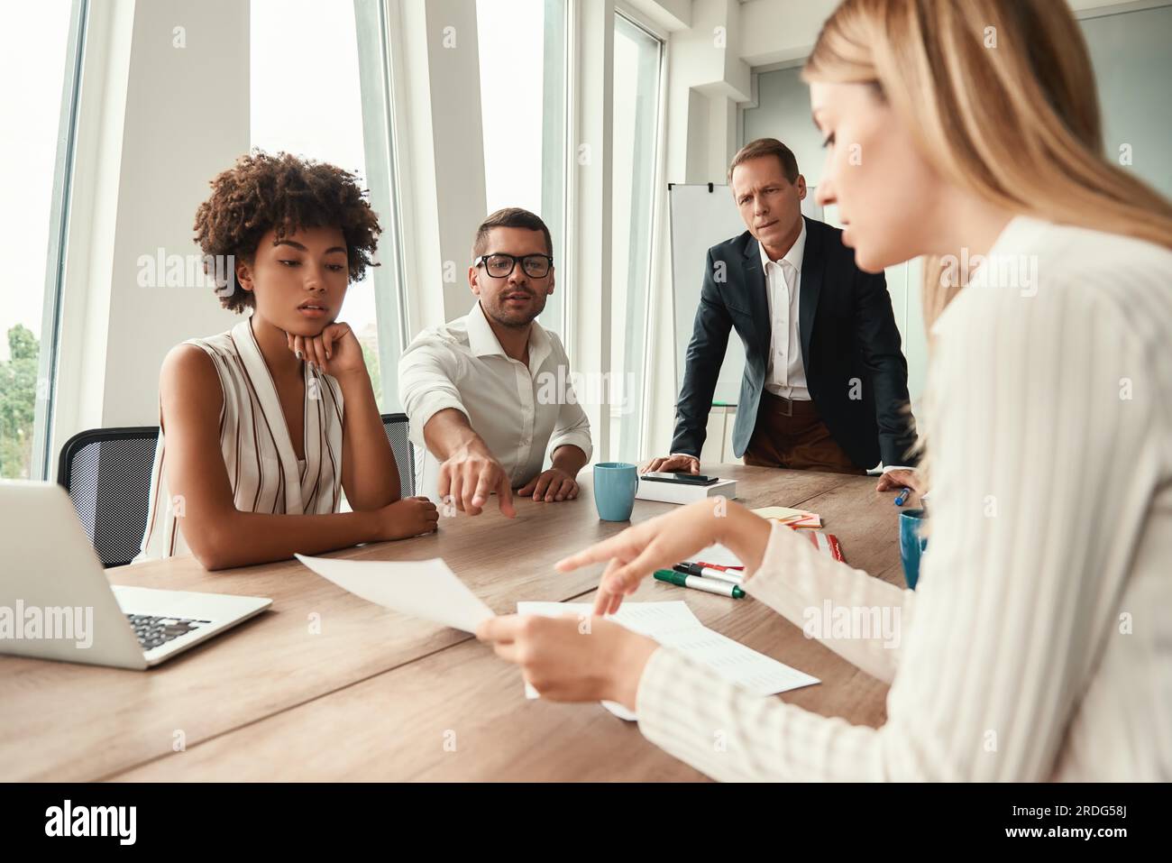 Business meeting. Group of young business people looking at documents ...
