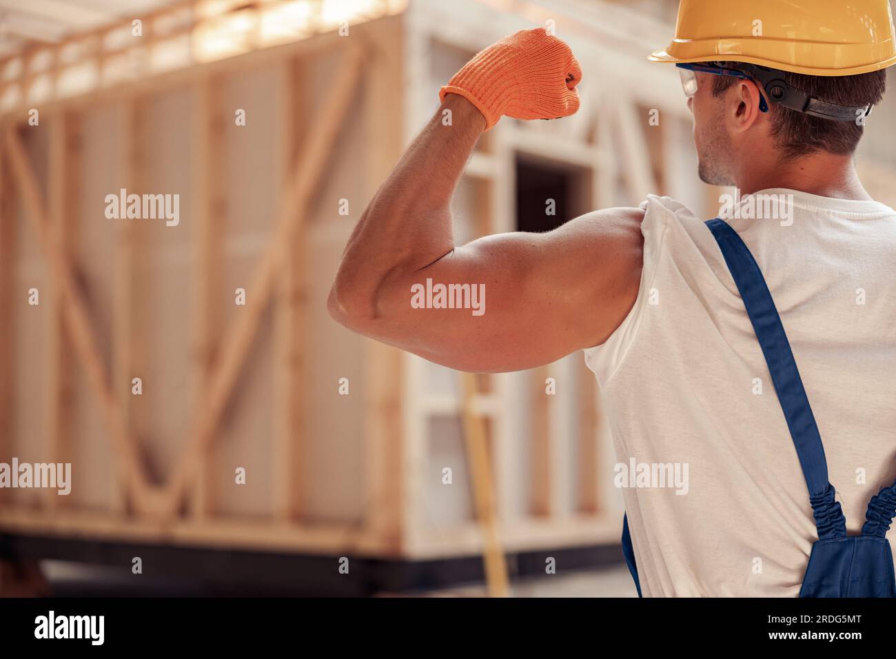 Athletic young man builder demonstrating his muscular arm Stock Photo ...