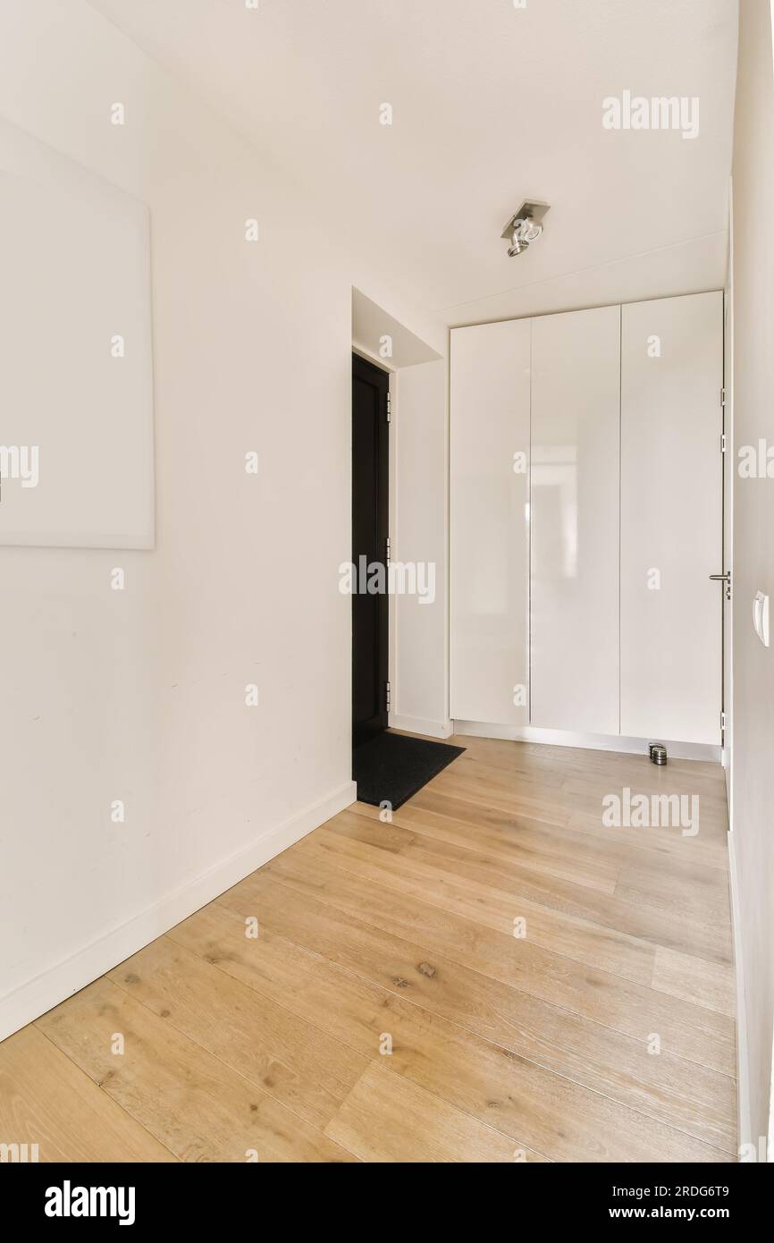 an empty room with white walls and wood flooring on the right, there is ...