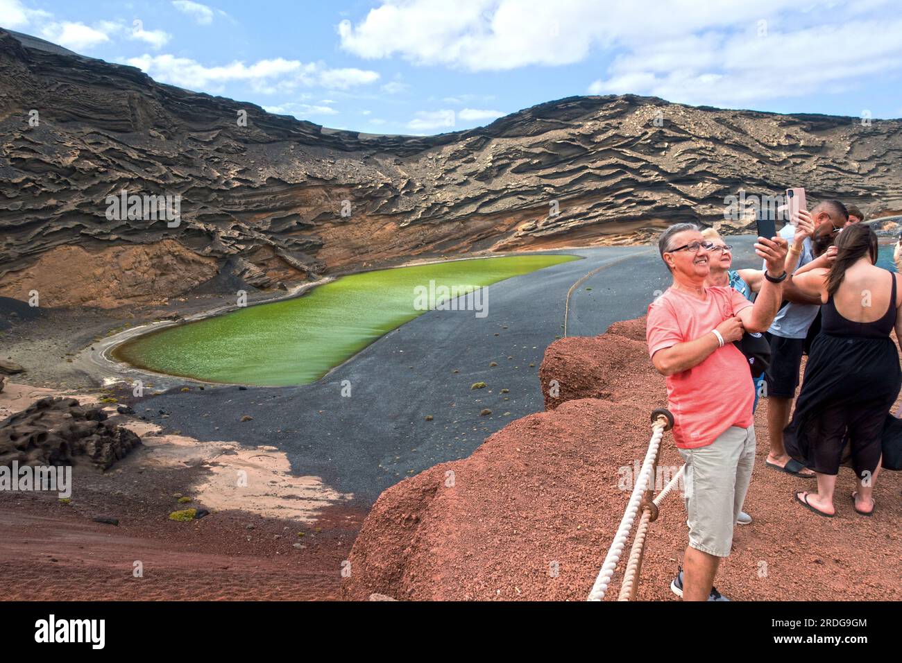 Tourists taking selfies at El Golfo, the volcanic green lake also known ...