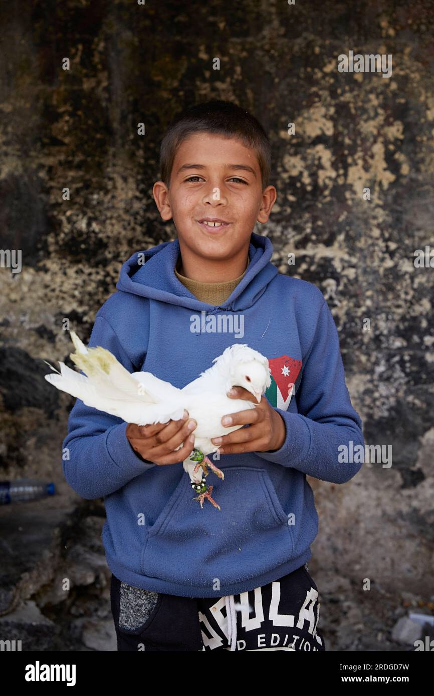 Portrait of a smiling boy holding a bird at the Bird market, Downtown ...