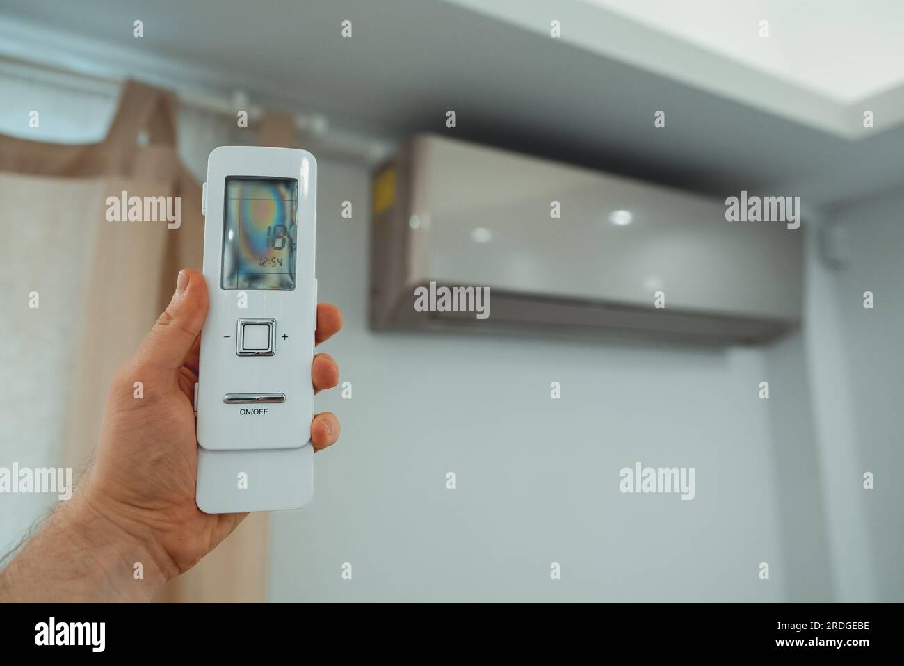 Hand holding remote control in front of the air conditioner Stock Photo ...