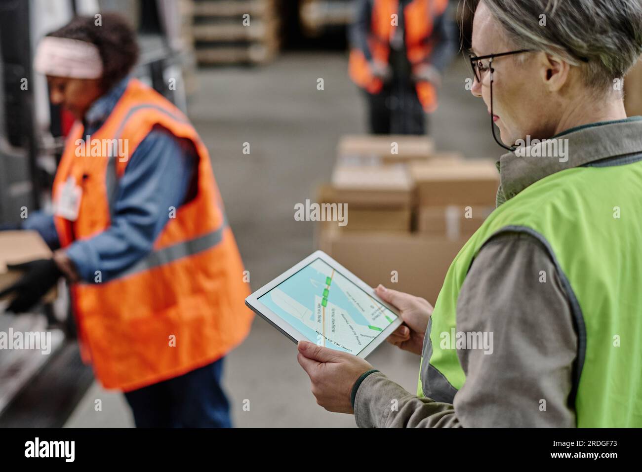 Rear view of manager checking the delivery route on digital tablet ...