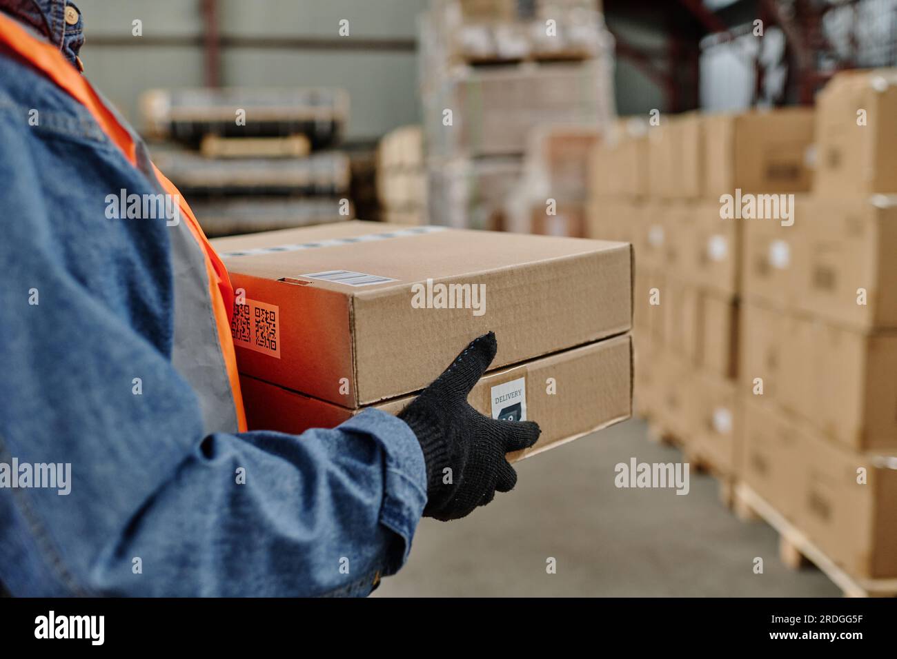 Close-up of worker carrying cardboard boxes for distribution in ...