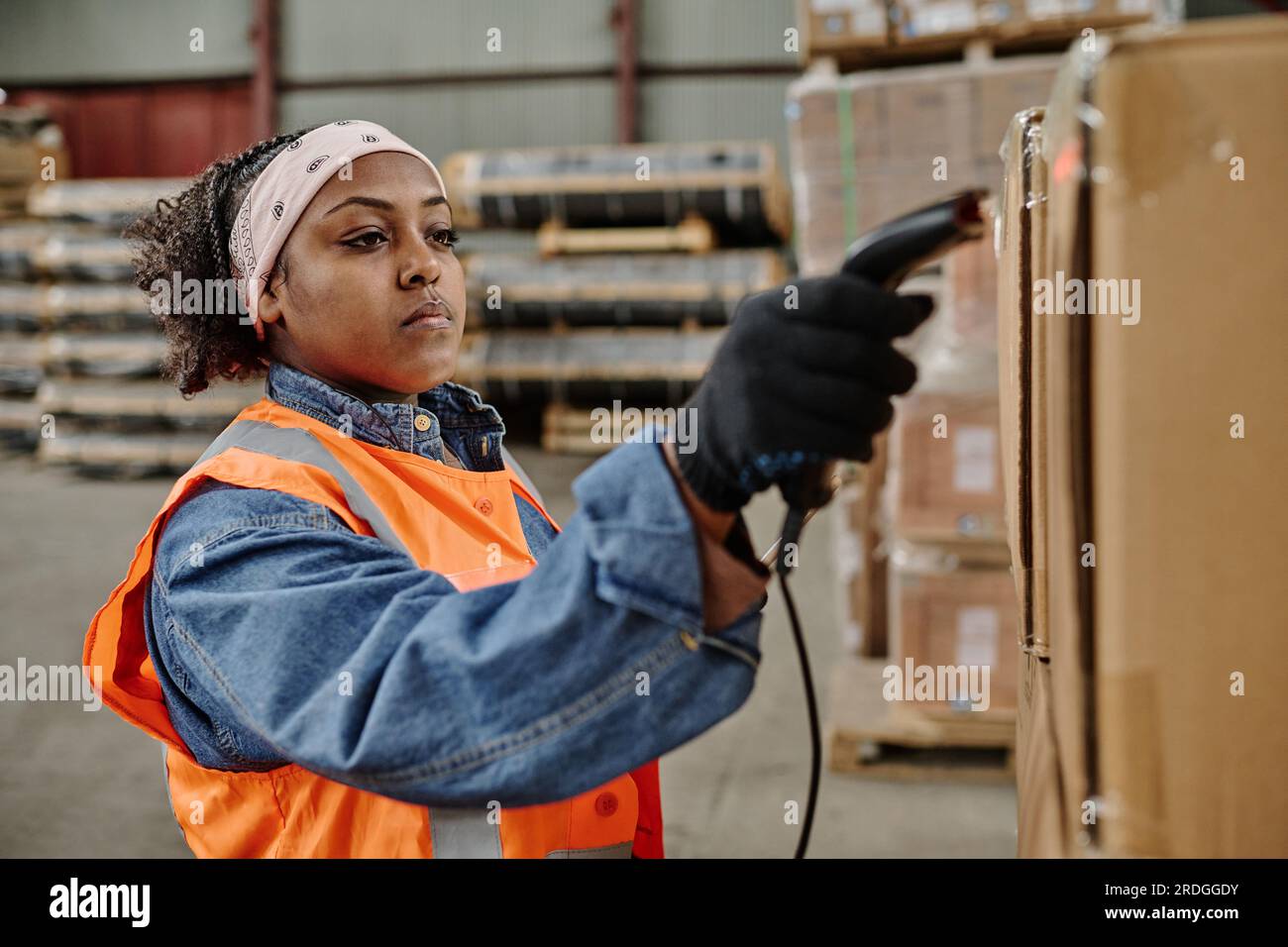 African American worker scanning codes with scanner on box during her ...