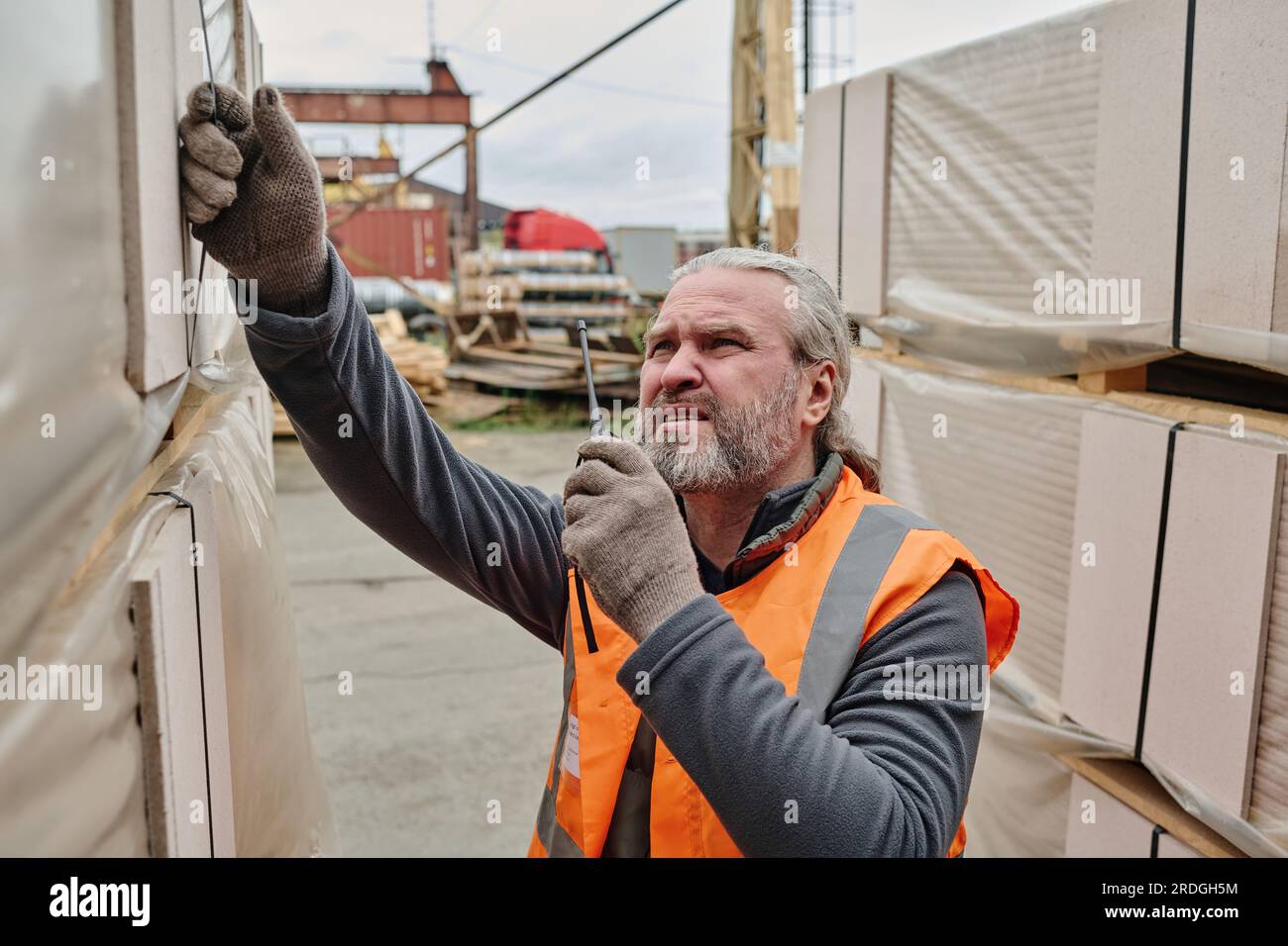Worker rewinding and pulling together the local big box with slings ...
