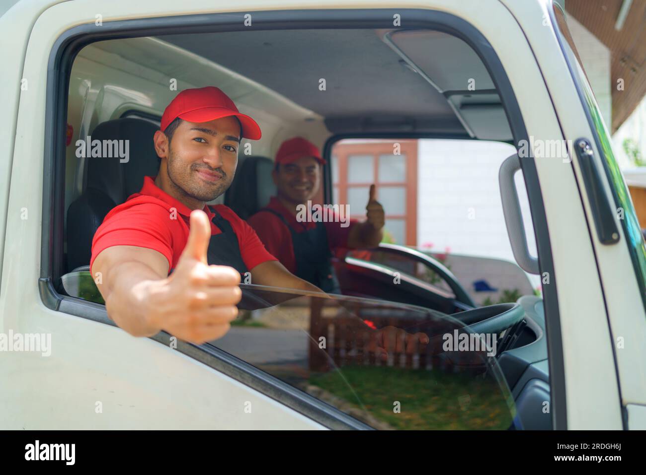 transport worker sits in the cargo truck, smiling with readiness and ...
