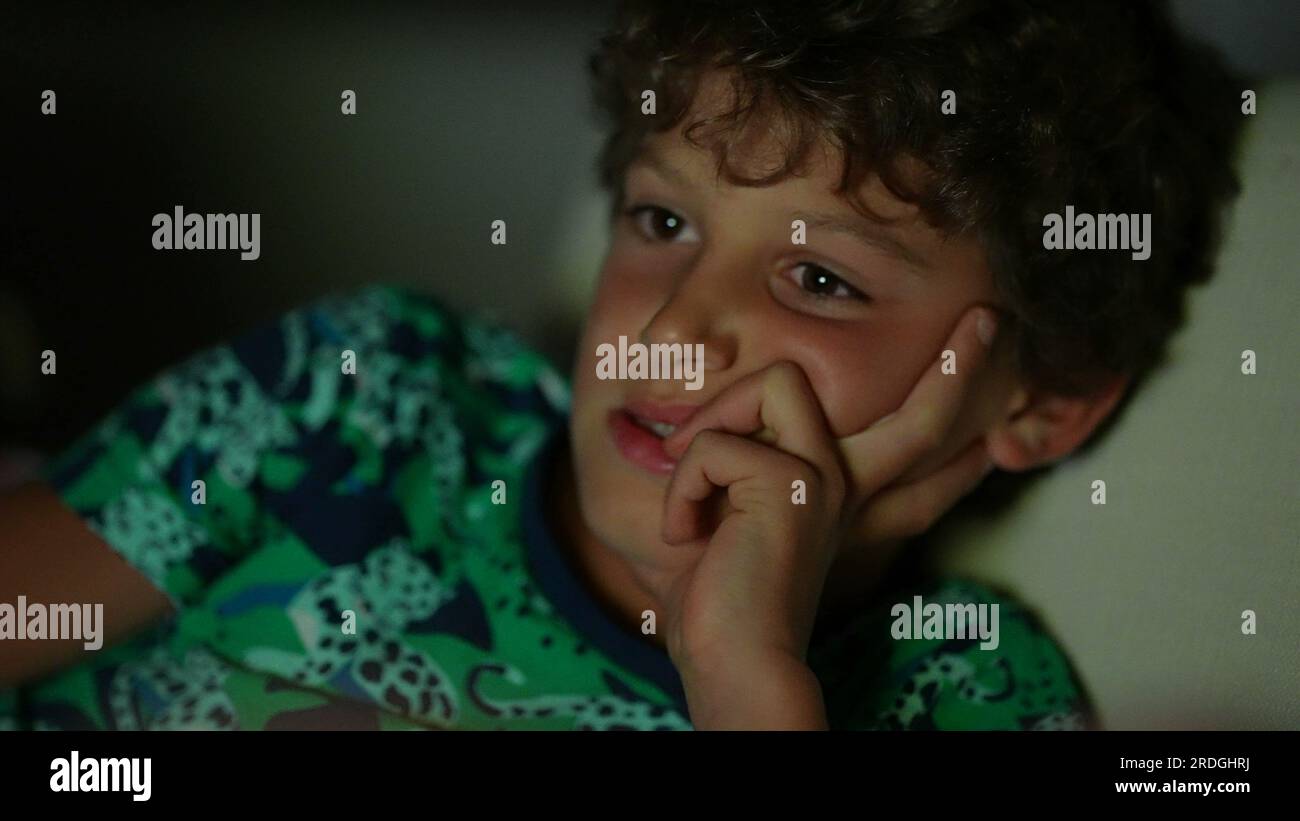 Small boy watching television screen at night Stock Photo - Alamy