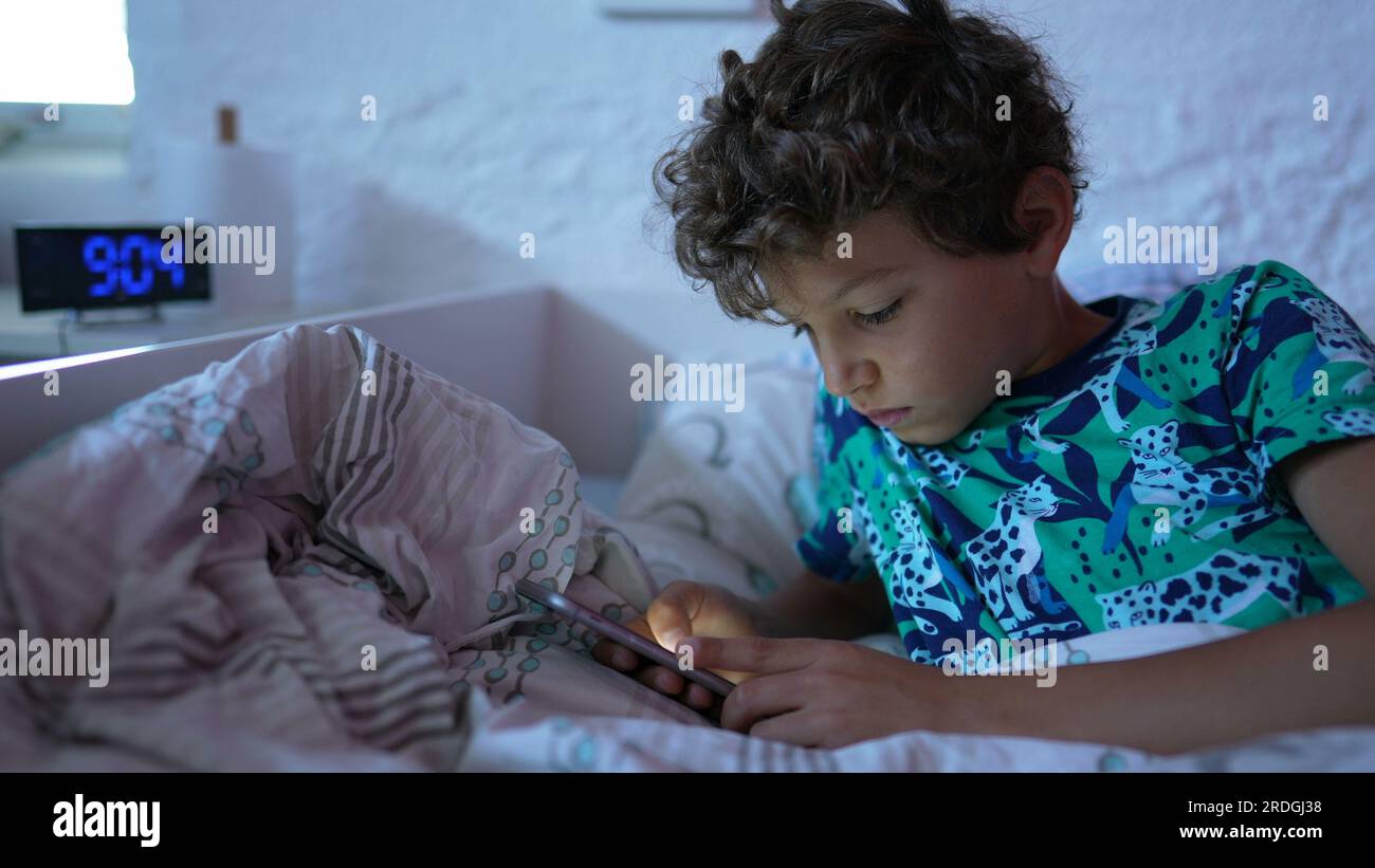 Youyng boy using cellphone in bedroom staring at screen Stock Photo - Alamy