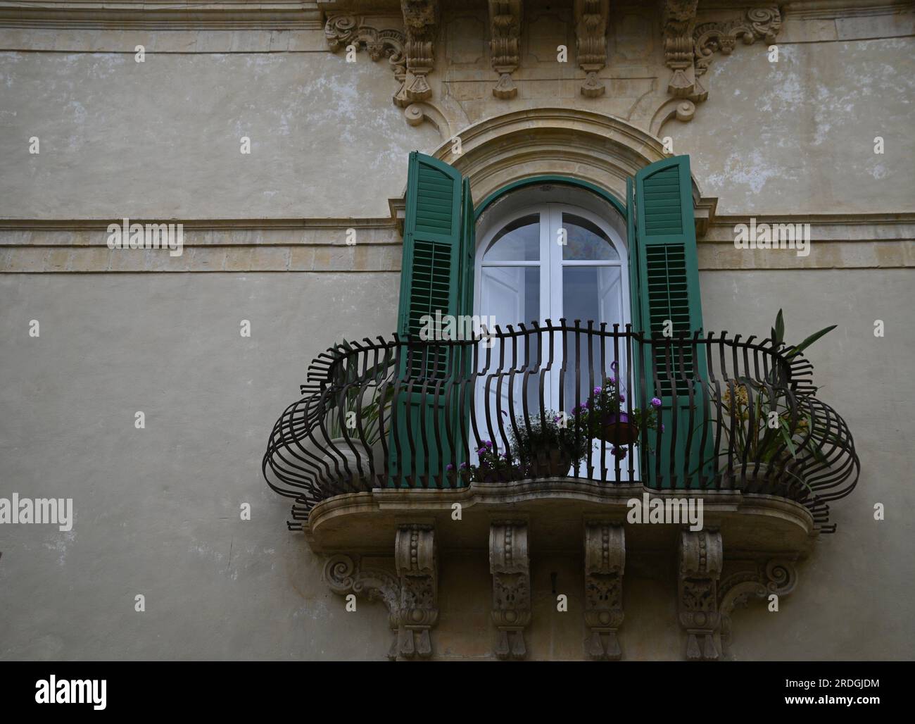 Antique house Rococo style facade with green wooden window shutters and ...