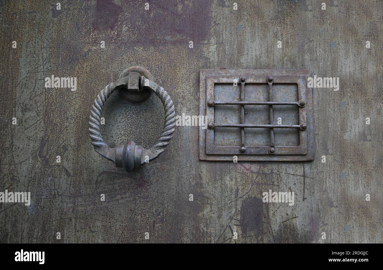 Antique handcrafted metal door with a vintage metal ring knocker and a ...