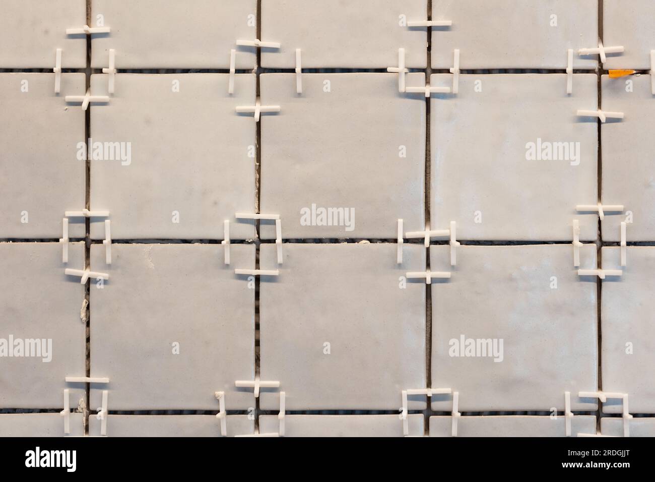 A front portrait of a tile wall under construction. The wall is being ...