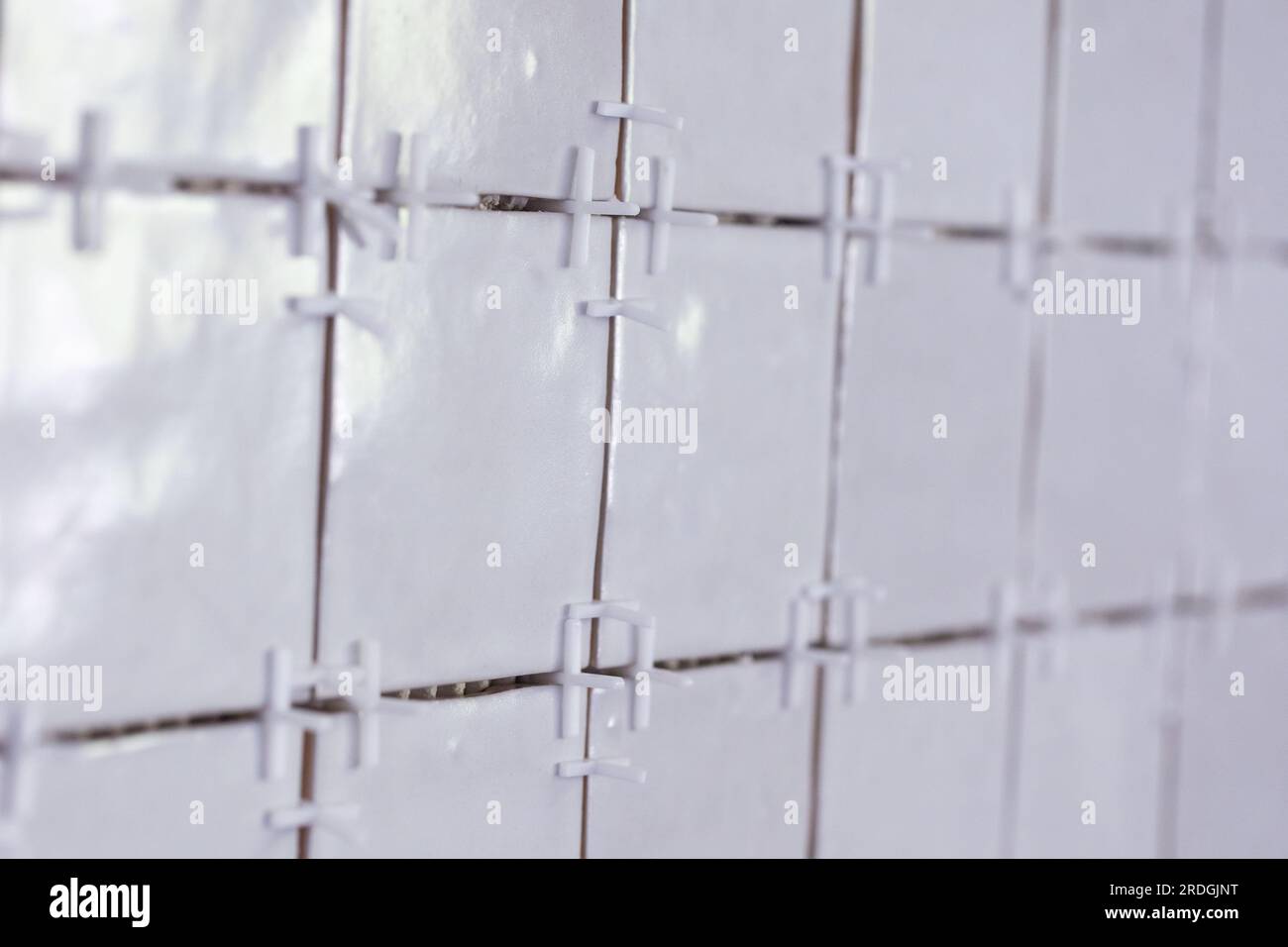 A close up of a tile wall under construction. The wall is being tiled ...