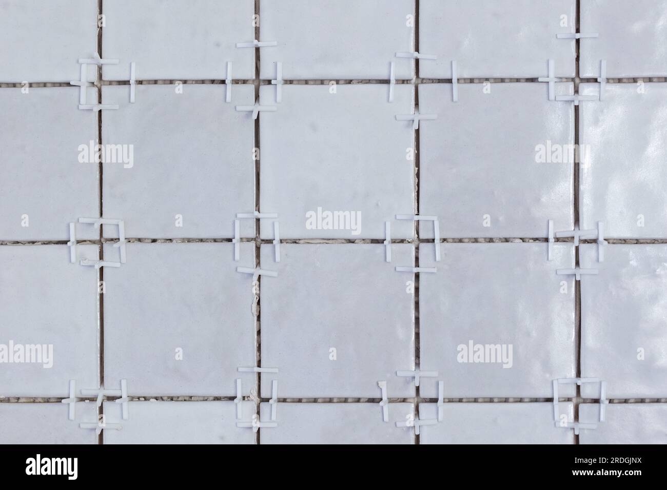 A front portrait of a tile wall under construction. The wall is being ...