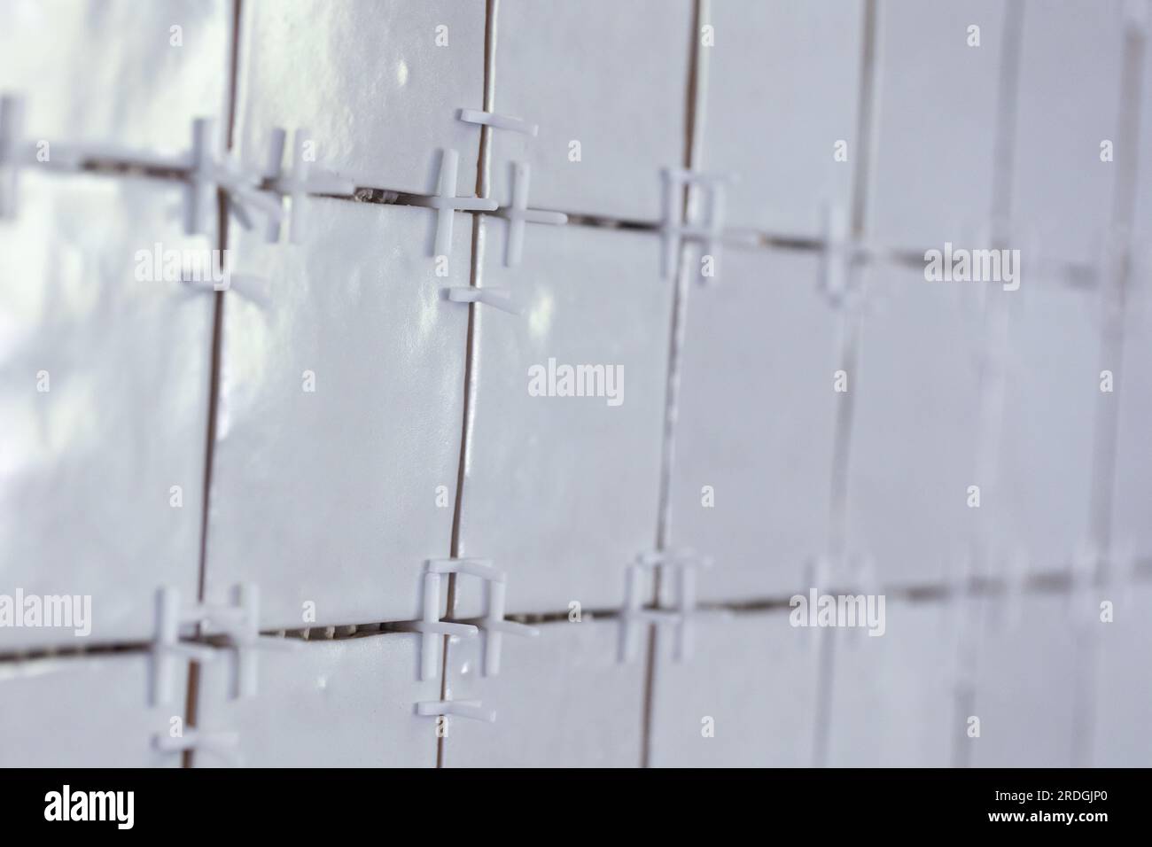 A tile wall under construction. The wall is being tiled with small ...