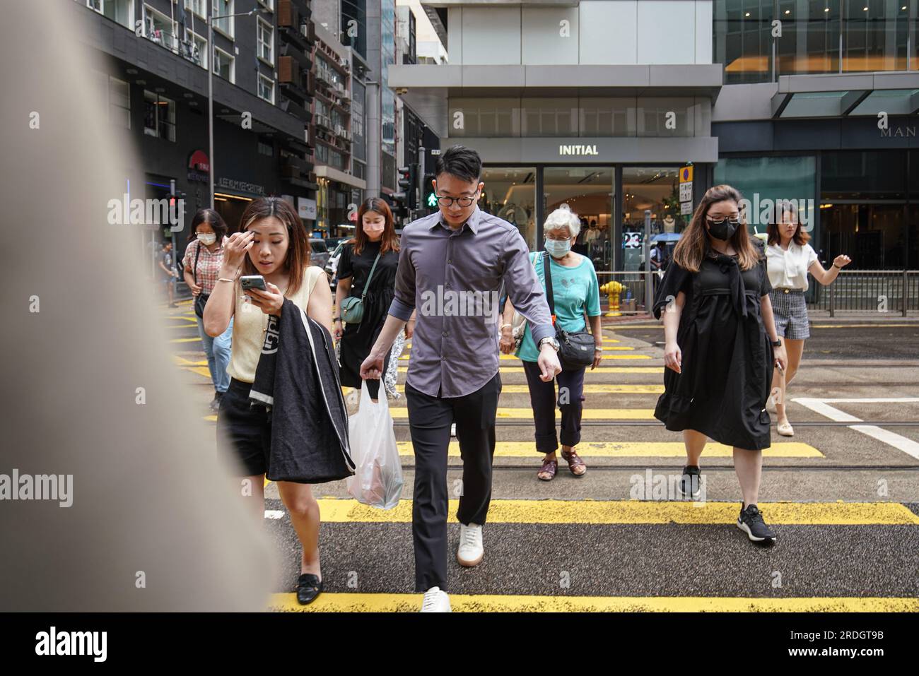 People walk across the street in Central Stock Photo - Alamy