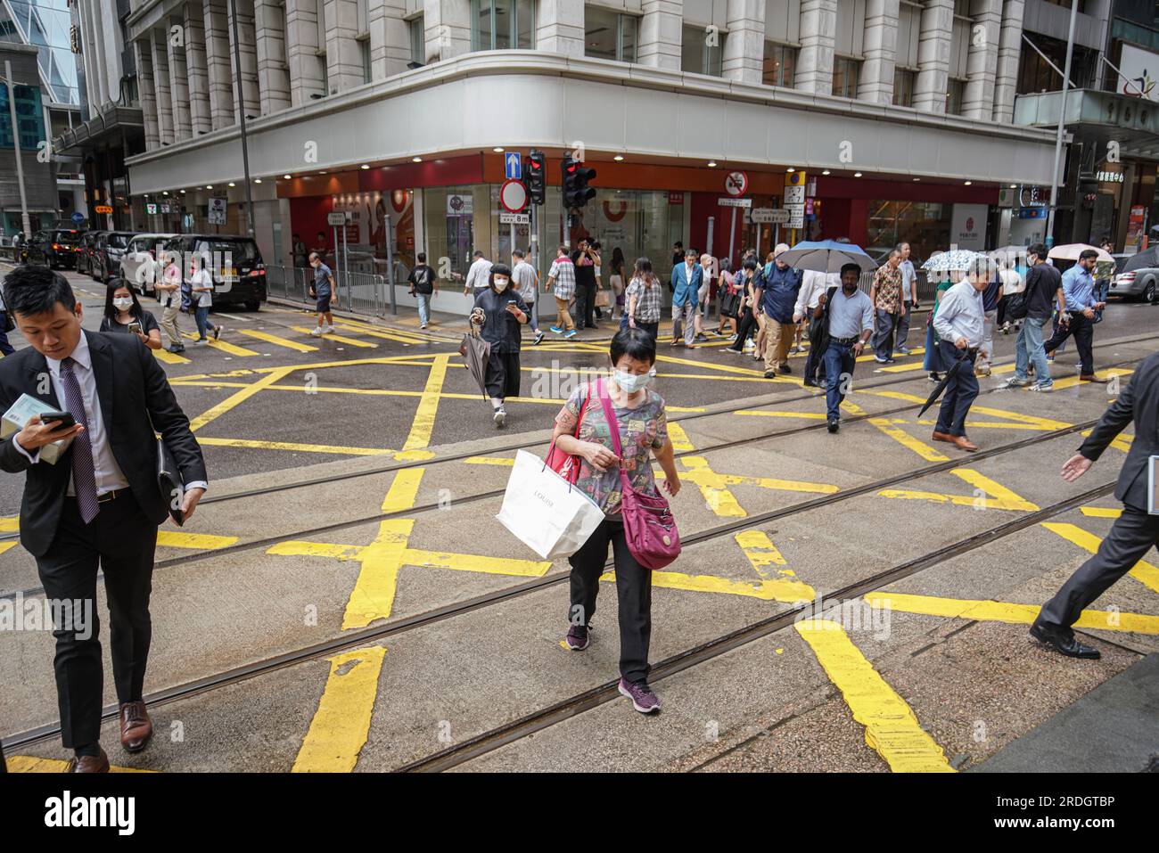 People walk across the street in Central Stock Photo - Alamy