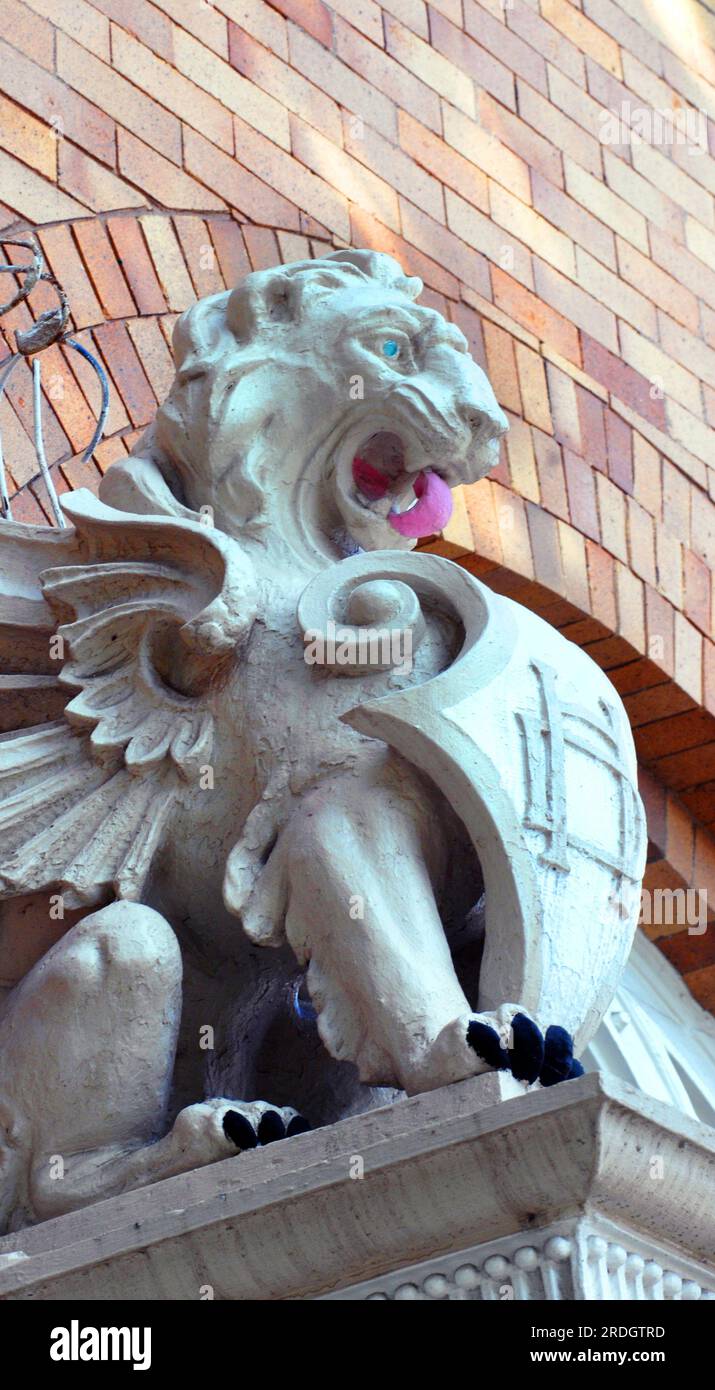 Concrete statue of lion, painted with blue eyes and pink tongue, stands ...