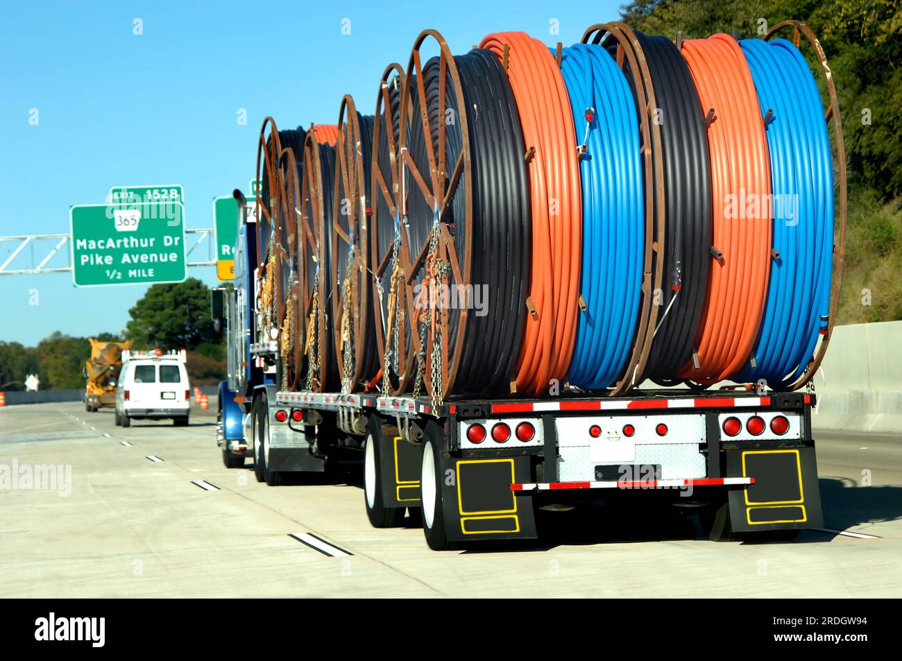 Big rig hauls spindles of multi-colored hose and pipe. Truck is hauling ...