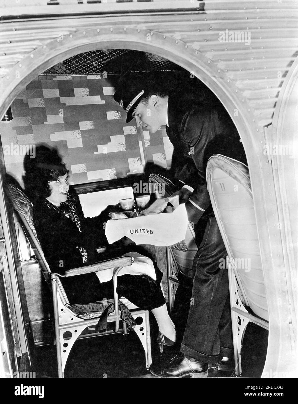 United States: c. 1928. Interior view of a steward serving a passenger ...