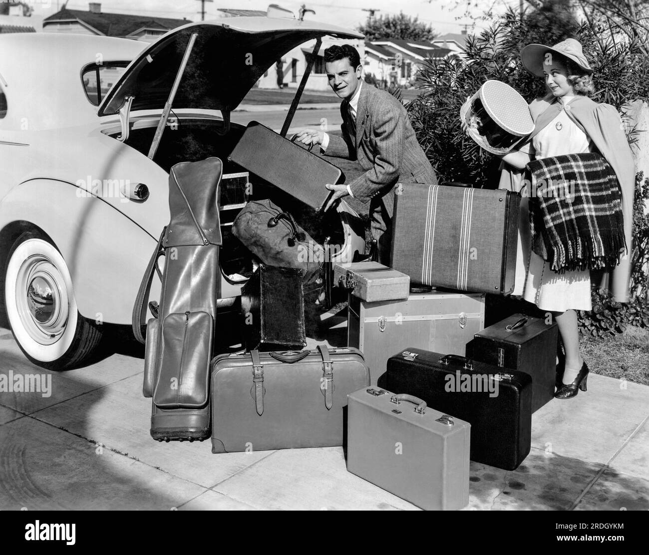 United States: c. 1939 A couple ready to go on vacation.. The man is ...