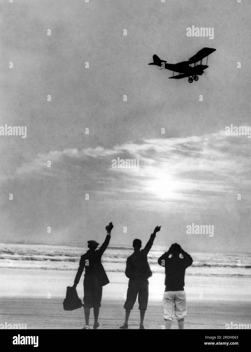 Florida: c. 1923 Three men wave to a biplane that has just taken off in ...