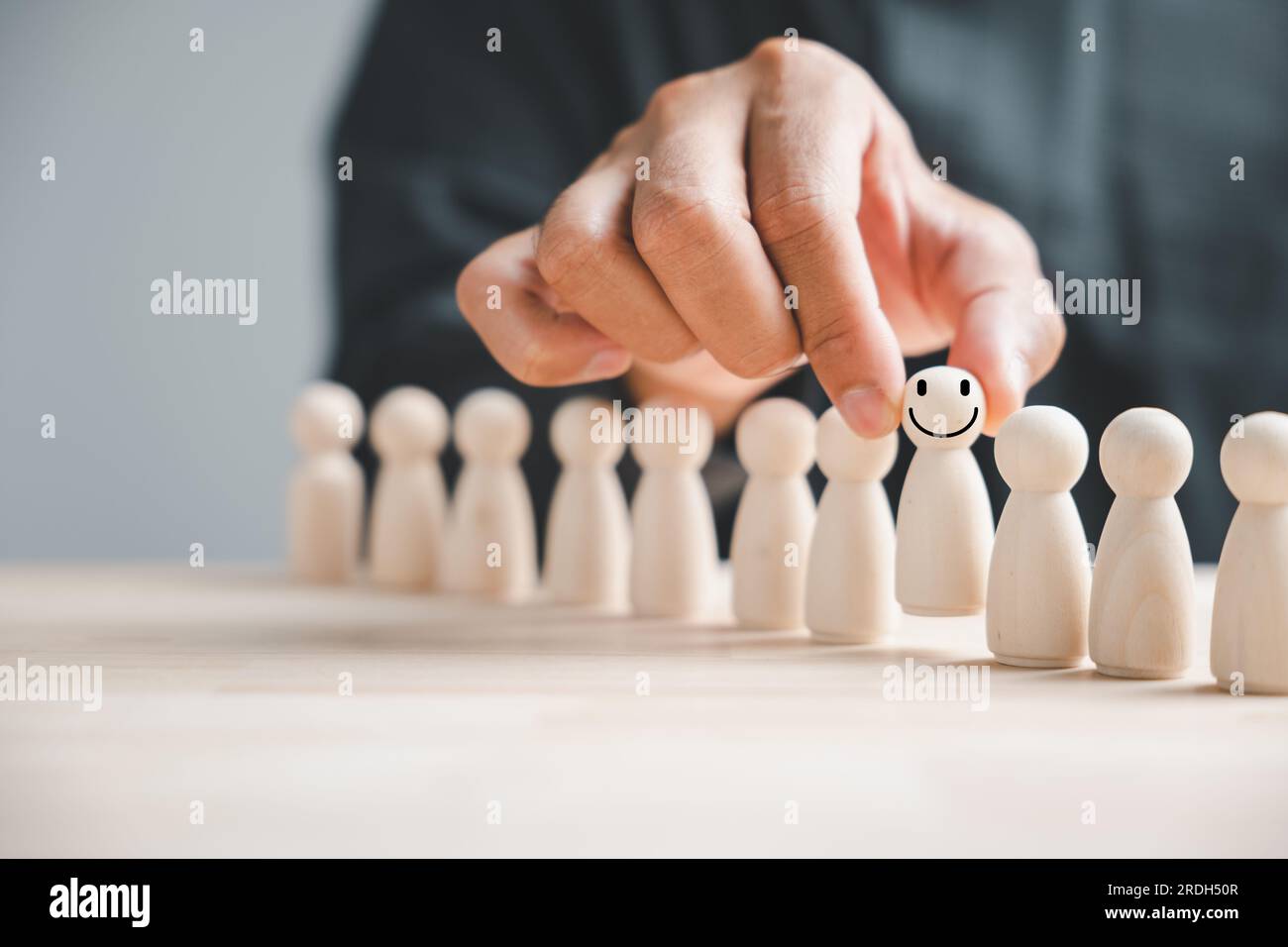 Hand choosing a wooden figure as the chosen leader from the crowd Stock ...