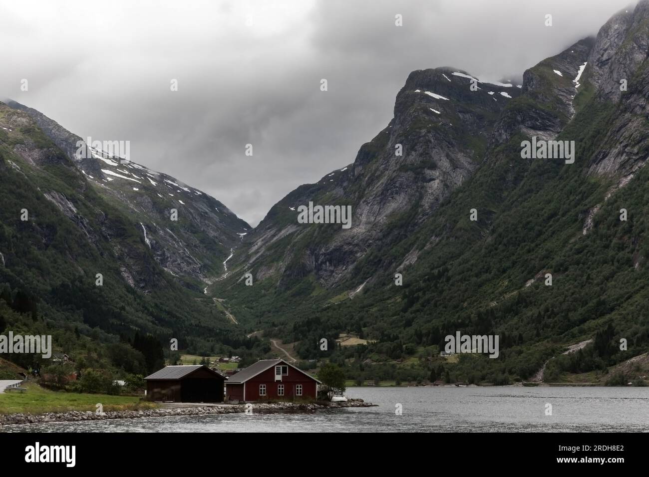 Traditional red Norwegian house standing alone in the fjord. Secluded ...