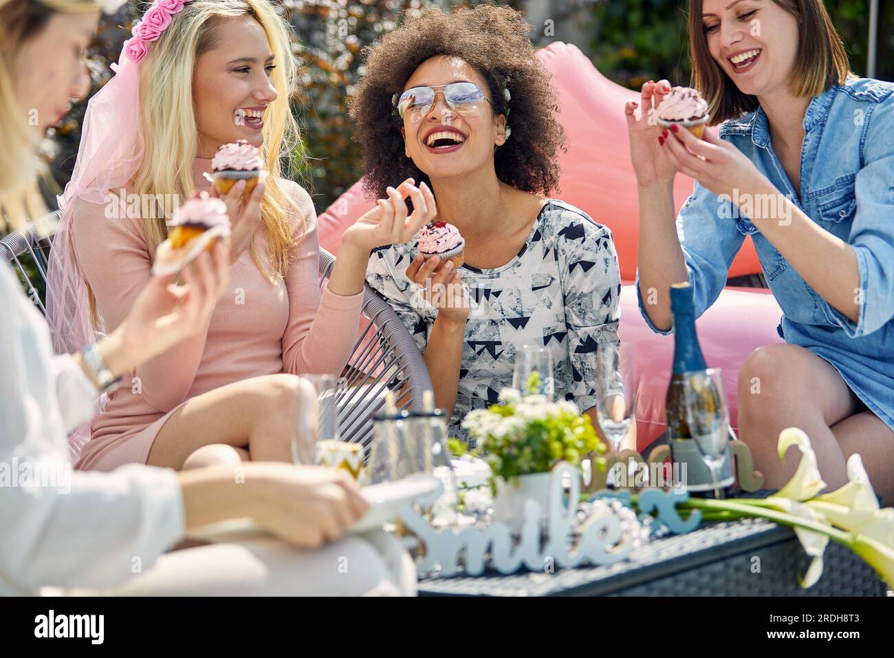 Four young women grlfriends sitting outdoors celebrating bachelorette ...