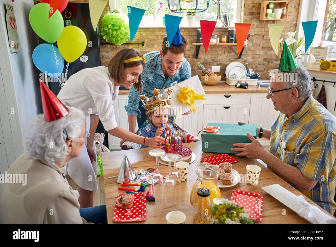 Young princess girl with an inflatable crown on her head, sitting by ...