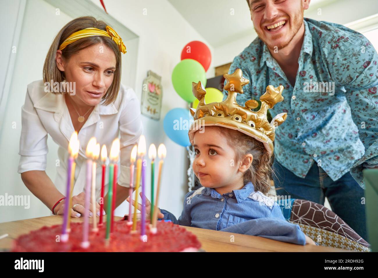 Preschool girl with crown celebrating birthday at home, sitting in ...