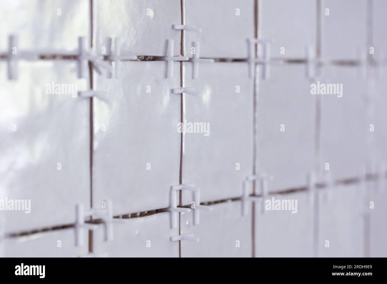 A close up of a tile wall under construction. The wall is being tiled ...