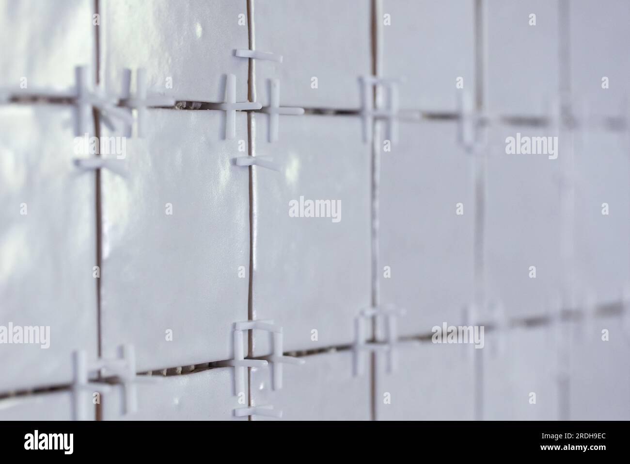 A portrait of a tile wall under construction. The wall is being tiled ...