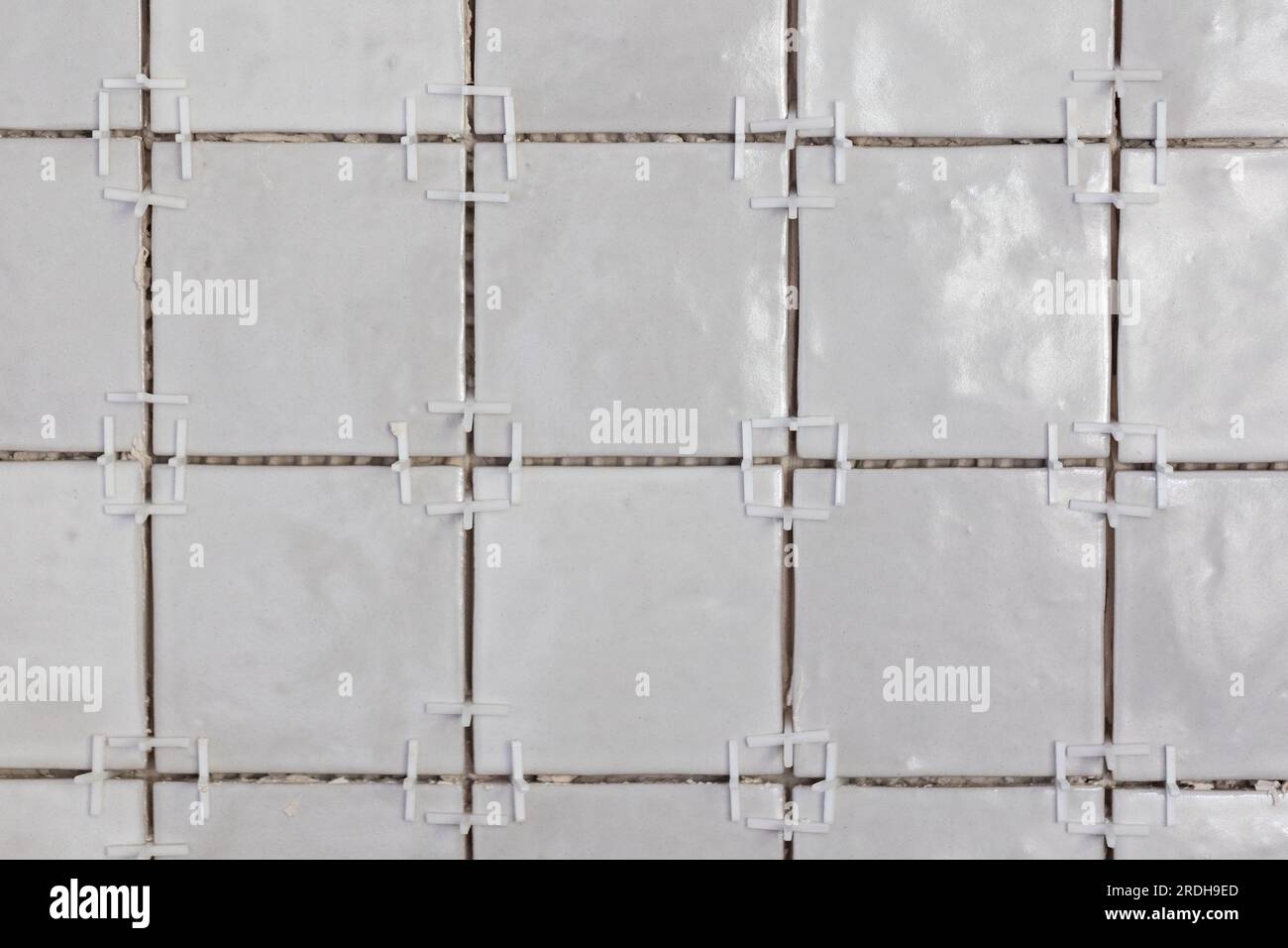 A front portrait of a tile wall under construction. The wall is being ...