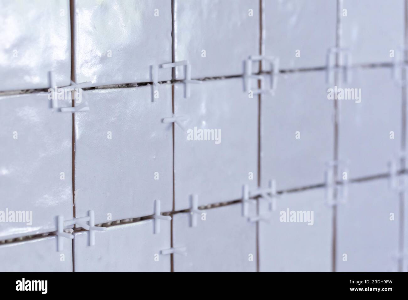 A close up of a tile wall under construction. The wall is being tiled ...