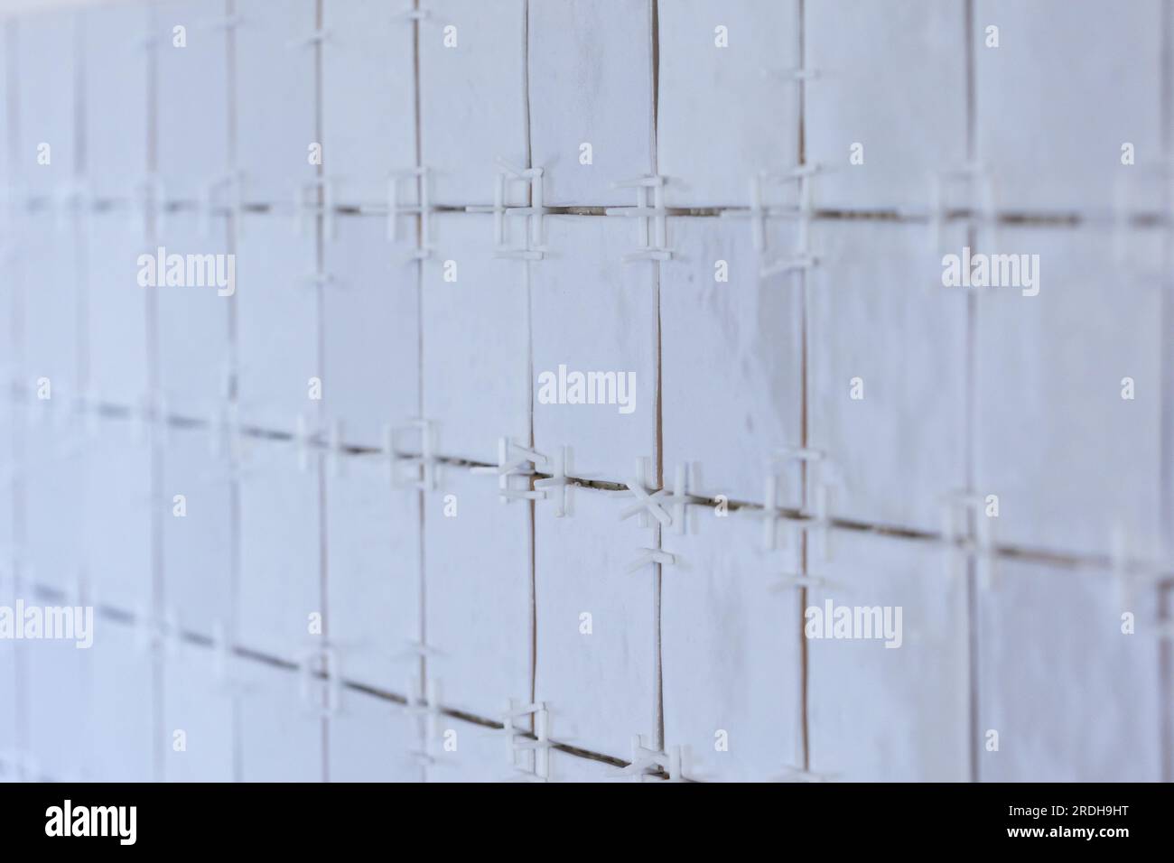 A portrait of a tile wall under construction. The wall is being tiled ...