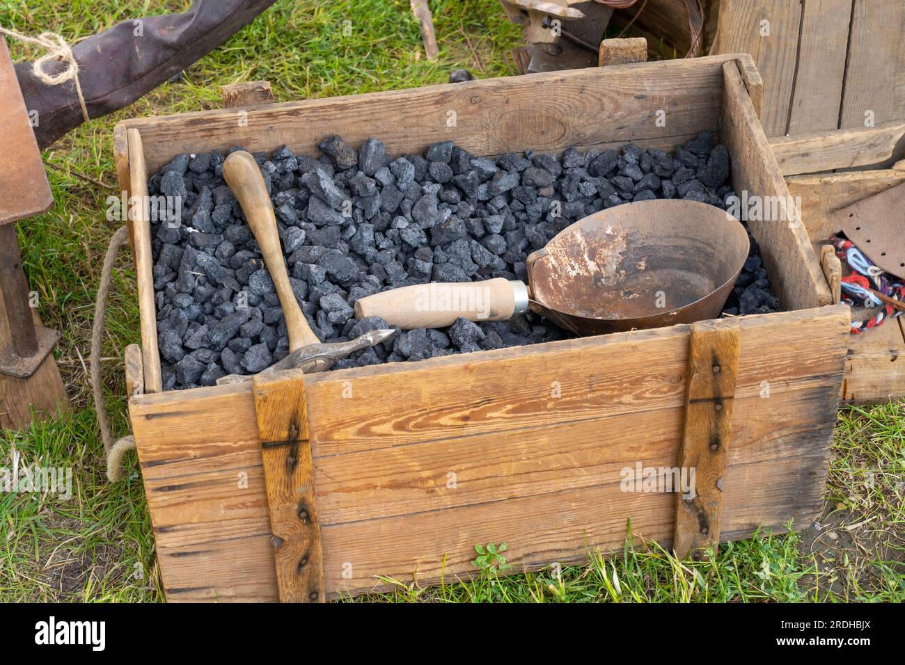 Coal stored in wooden chest with tools in a forge Stock Photo - Alamy