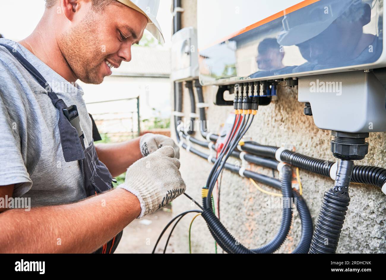 Man electrician installing solar panel system. Technician in helmet and ...