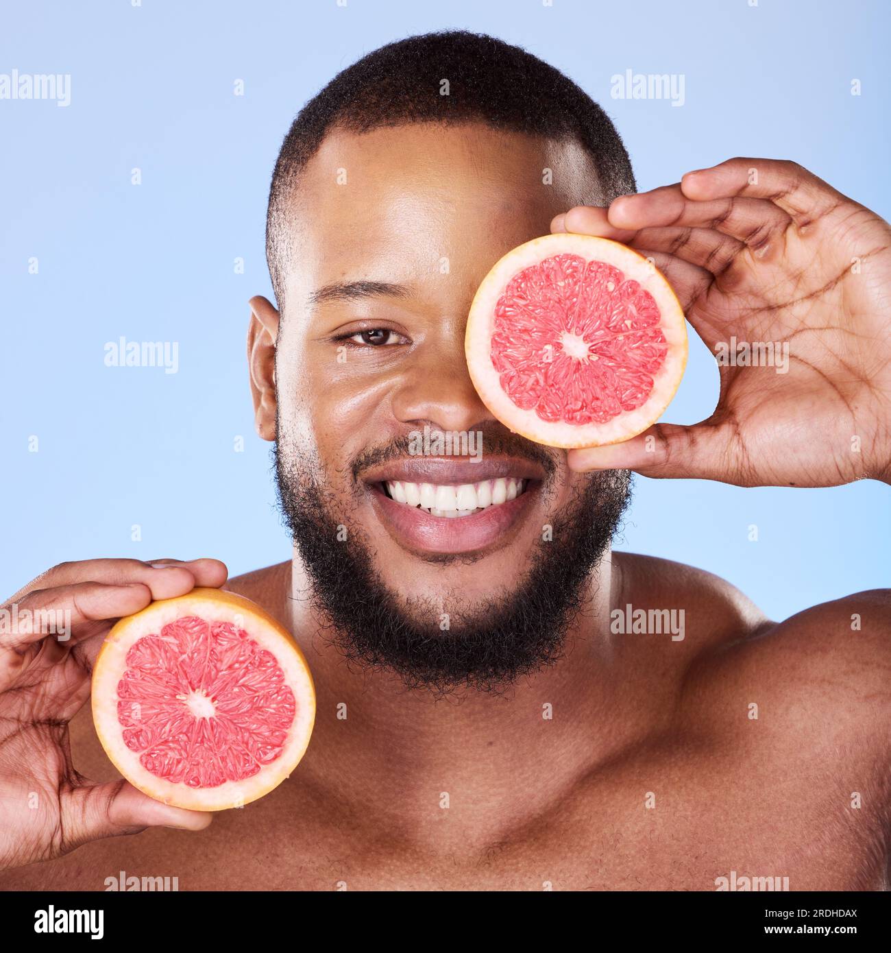 Black man, grapefruit and studio portrait for skincare, detox or vitamin c for smile, health or ...