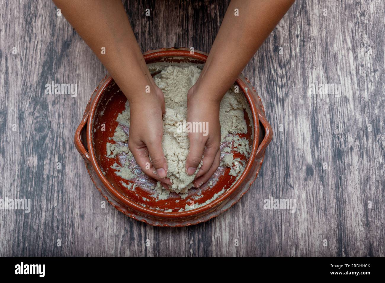 Woman's hands mixing corn dough to make tortillas. Mexican basic food ...
